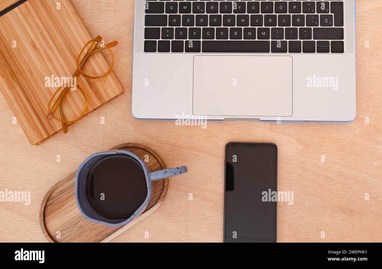 Overhead shot of laptop, coffee, and phone on desk Stock Photo - Alamy