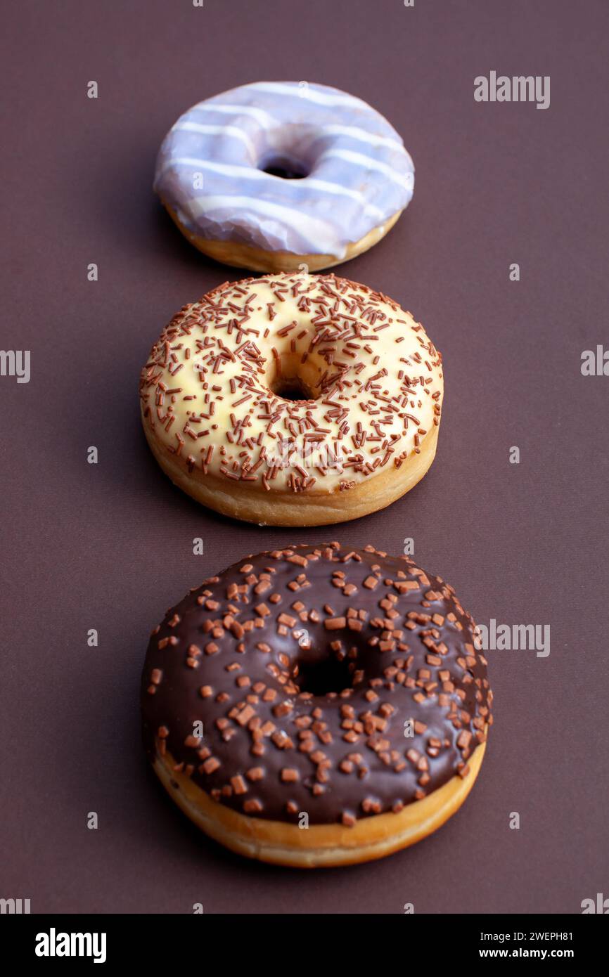three ring doughnuts isolated on brown background Stock Photo - Alamy