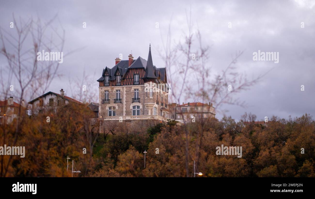 A castle stands amidst a forest-covered hill, at Biarritz, France Stock ...