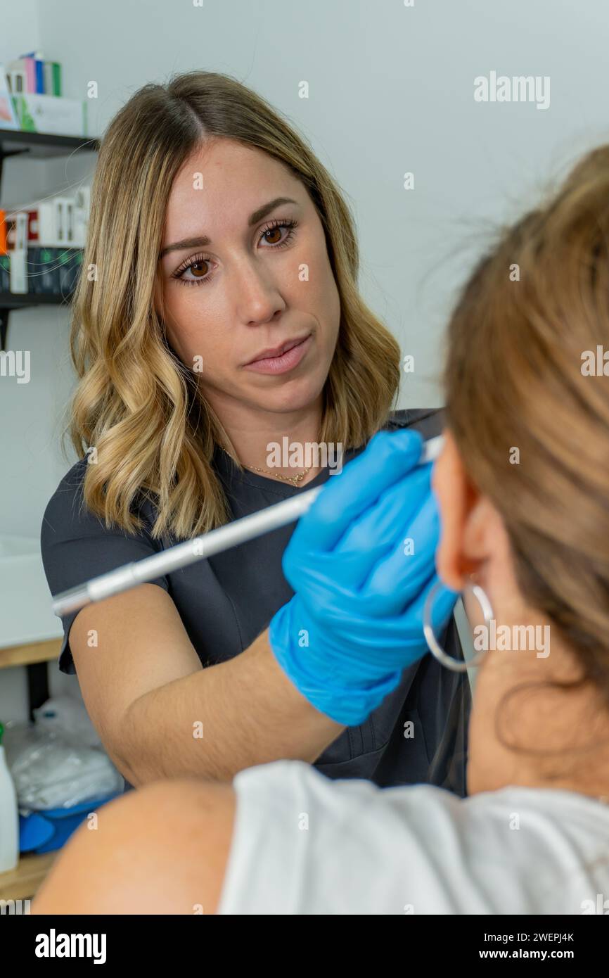 serious beautician make marks with pen on face of adult woman Stock ...