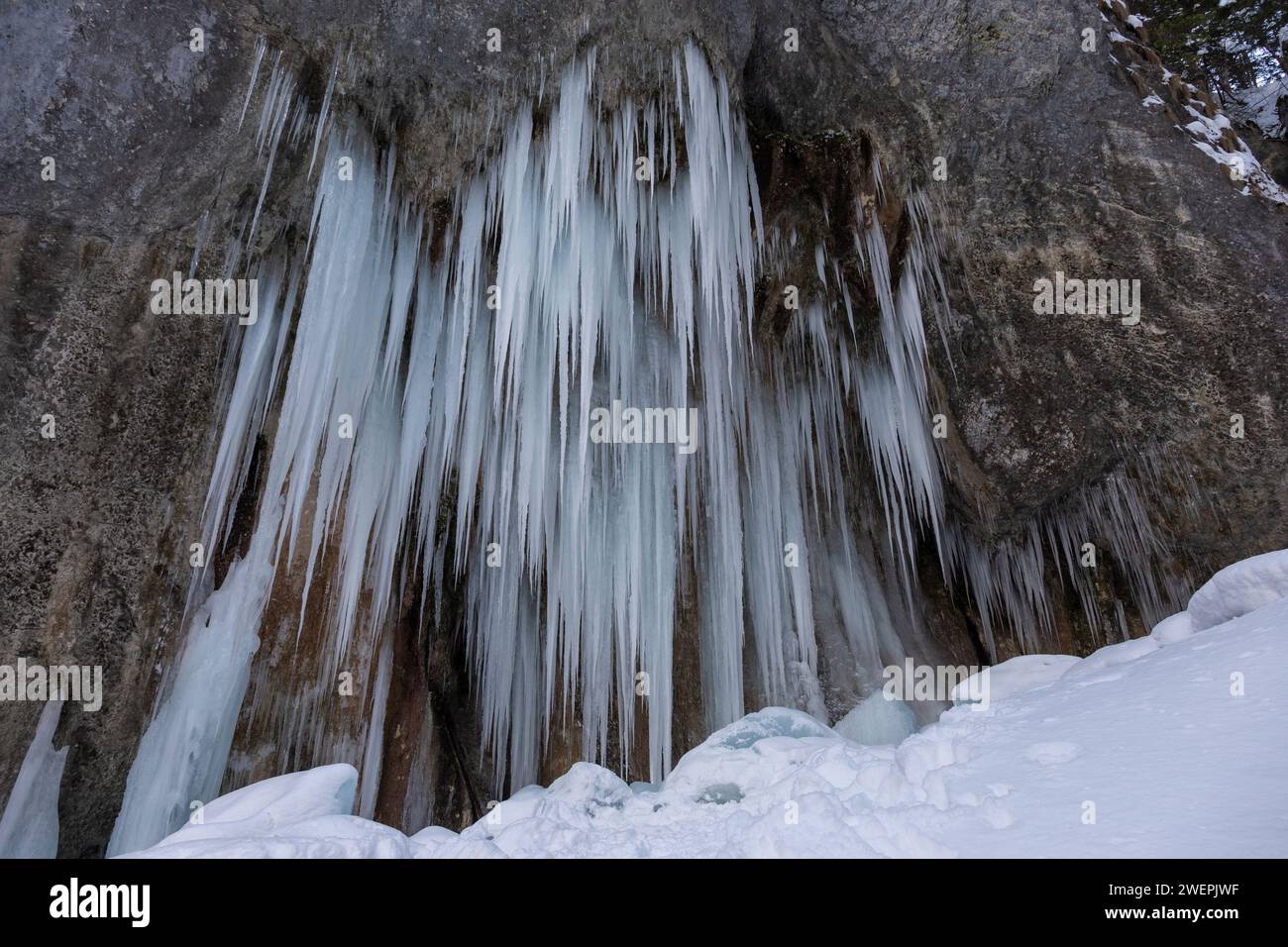 Huge icicles on the rock face Stock Photo - Alamy