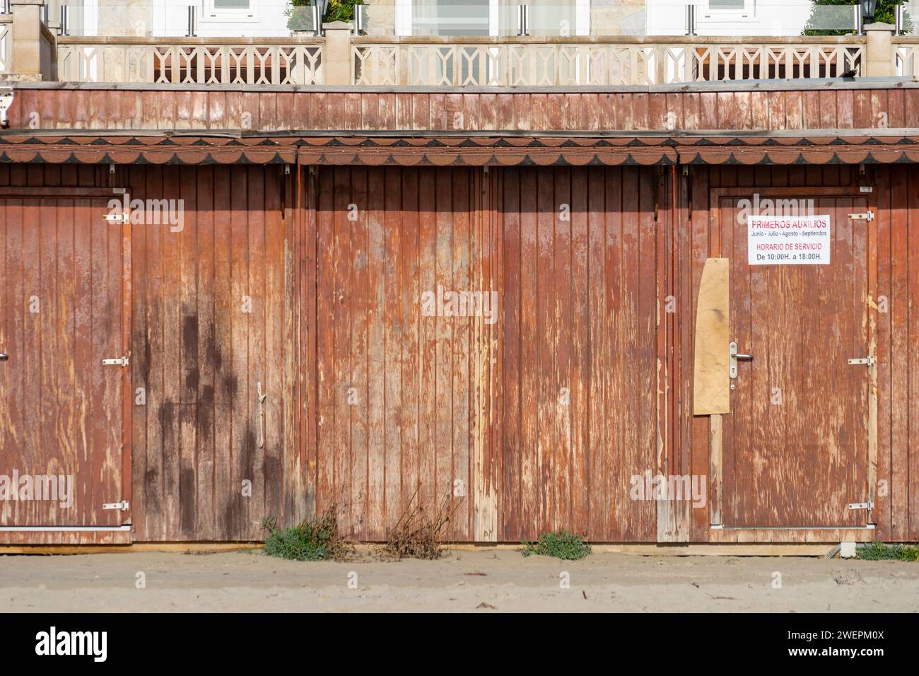 A row of rustic, weathered beach huts stands with a quiet history ...