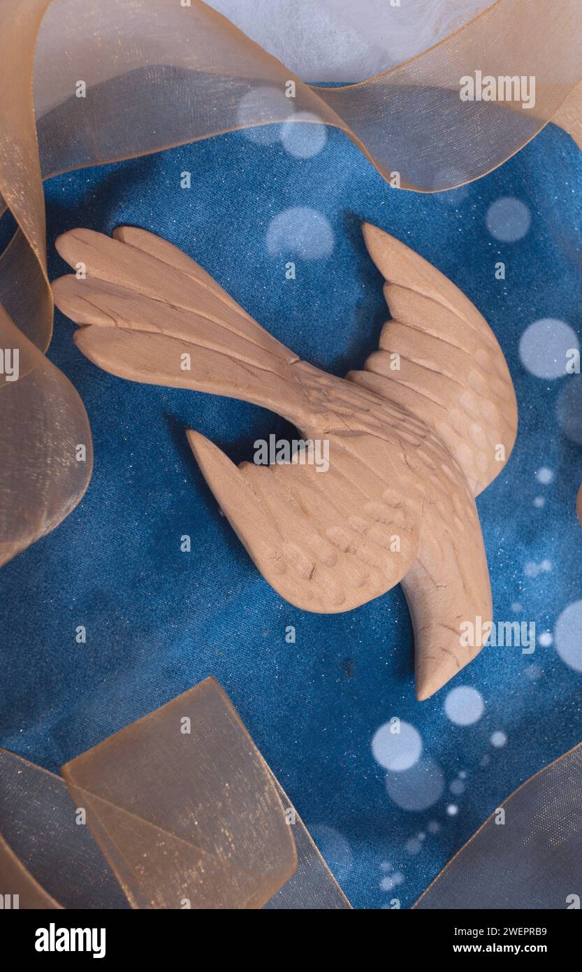 Descending sculpted dove bird in bokeh blue background with gold ...