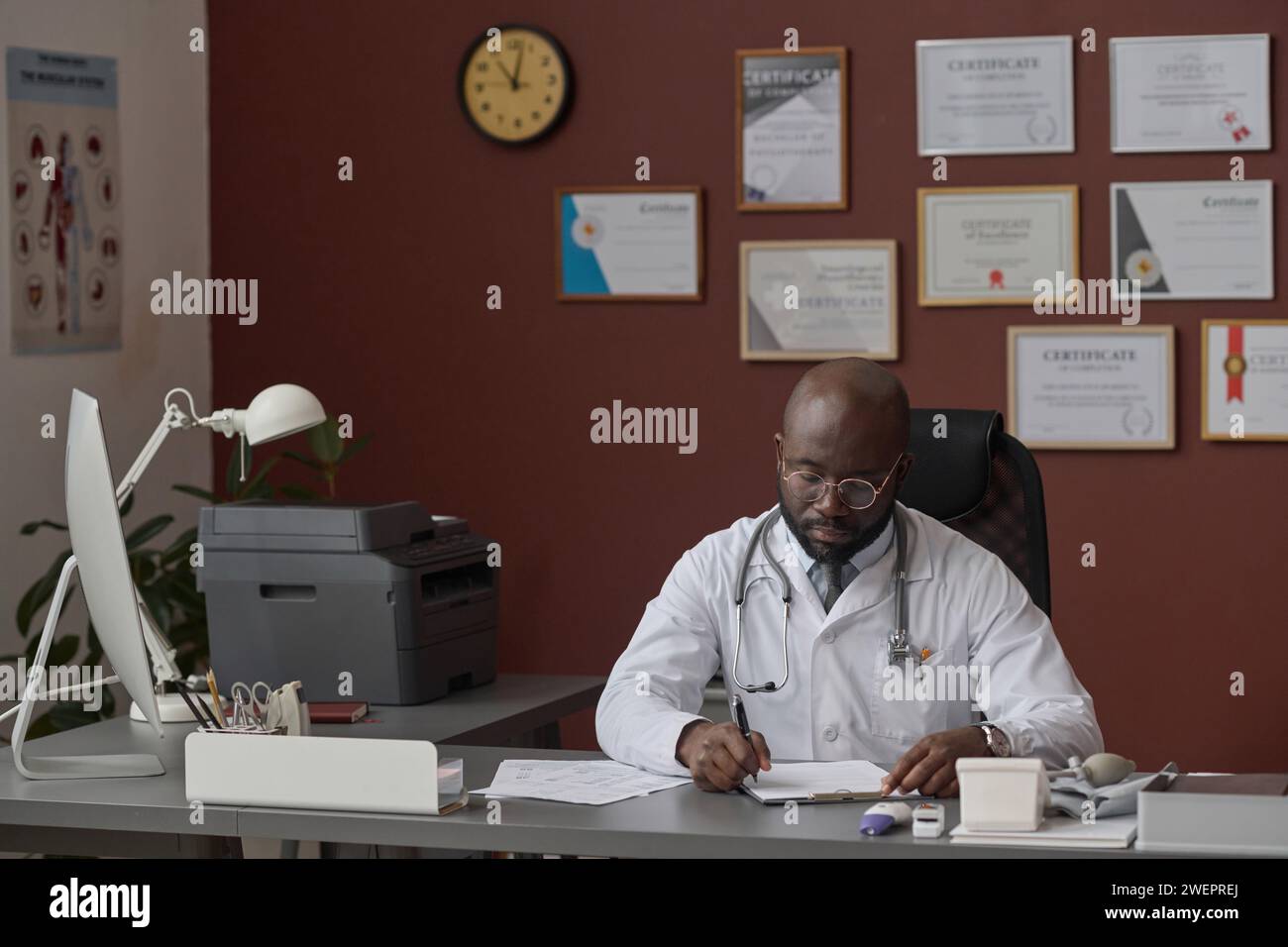 African american doctor sitting alone at his office desk and working ...