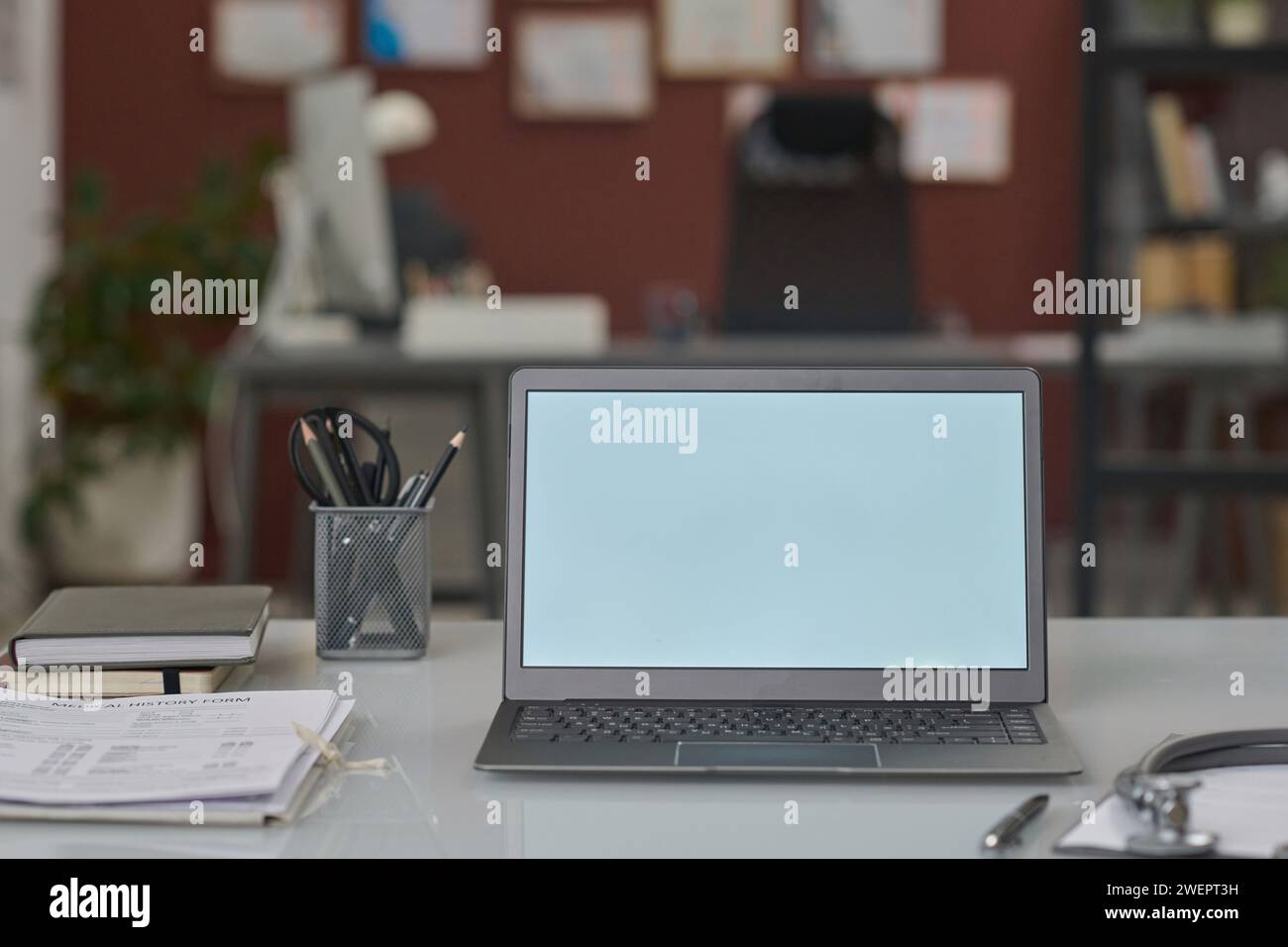 Laptop with white blank screen placed on hospital office desk amid ...