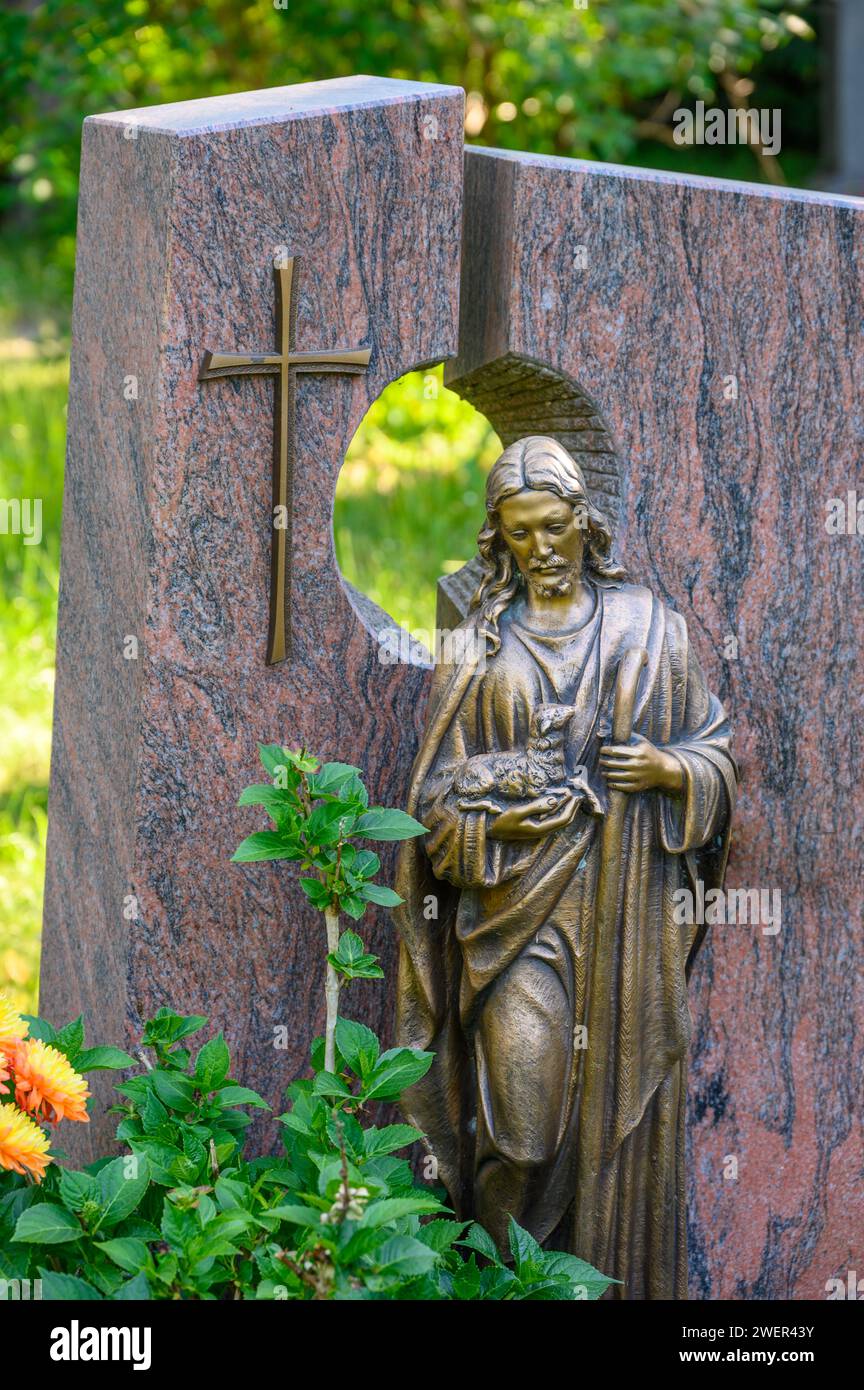 Decorated grave with a gravestone with cross and "The Good Shepherd ...
