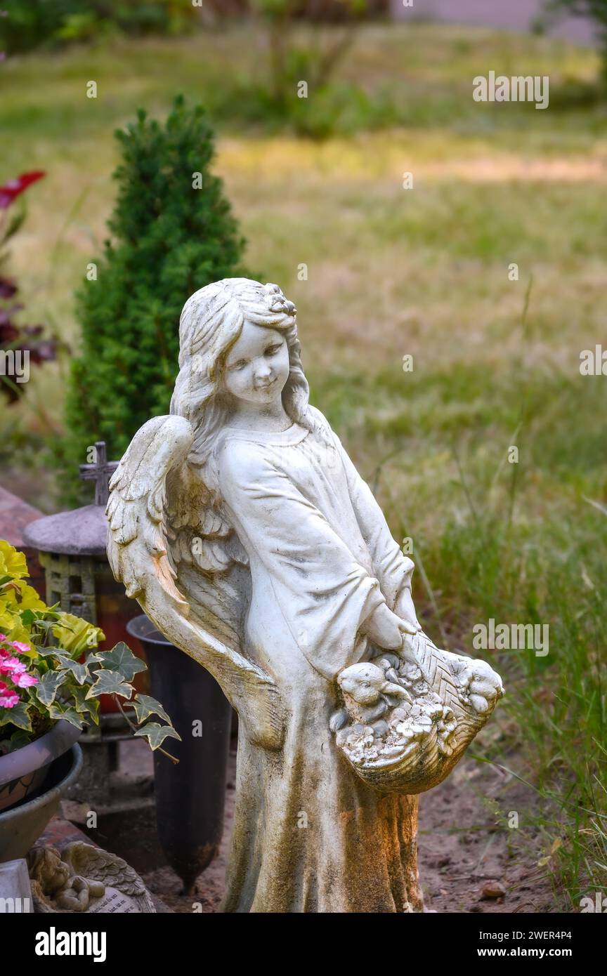 Childlike angel statue with basket at a gravesite Stock Photo - Alamy