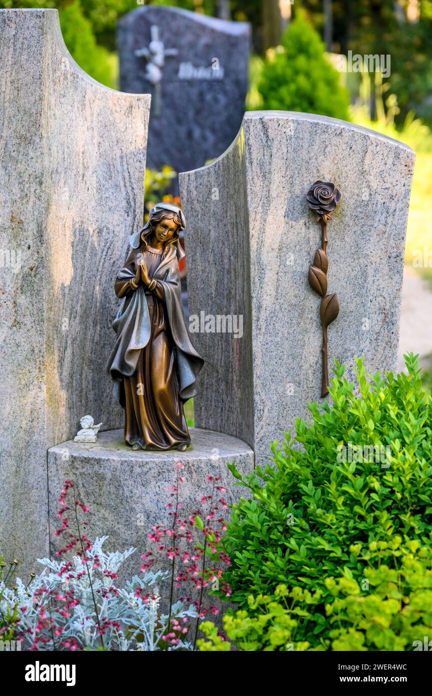 Standing Madonna figure on gravestone with rose at the cemetery Stock ...