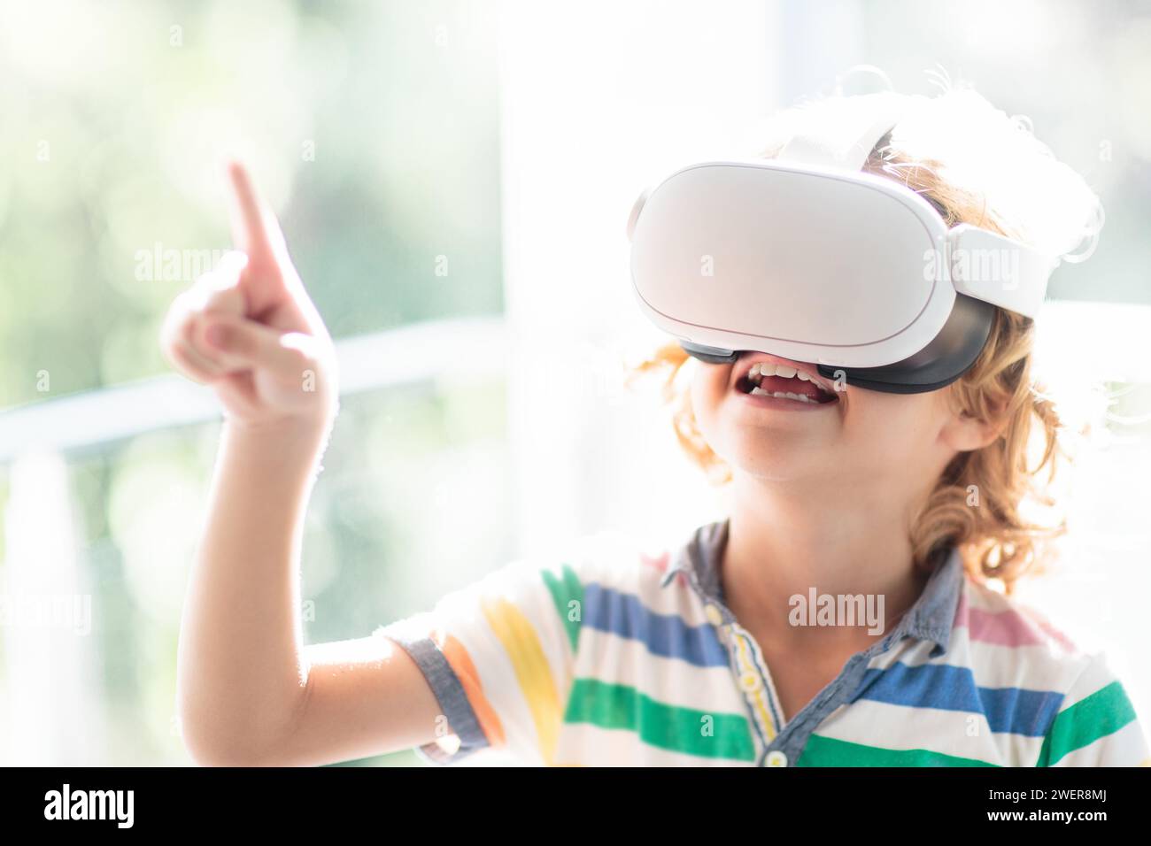 Child in virtual reality goggles. VR set for kids. Little boy playing computer game. Learning ...