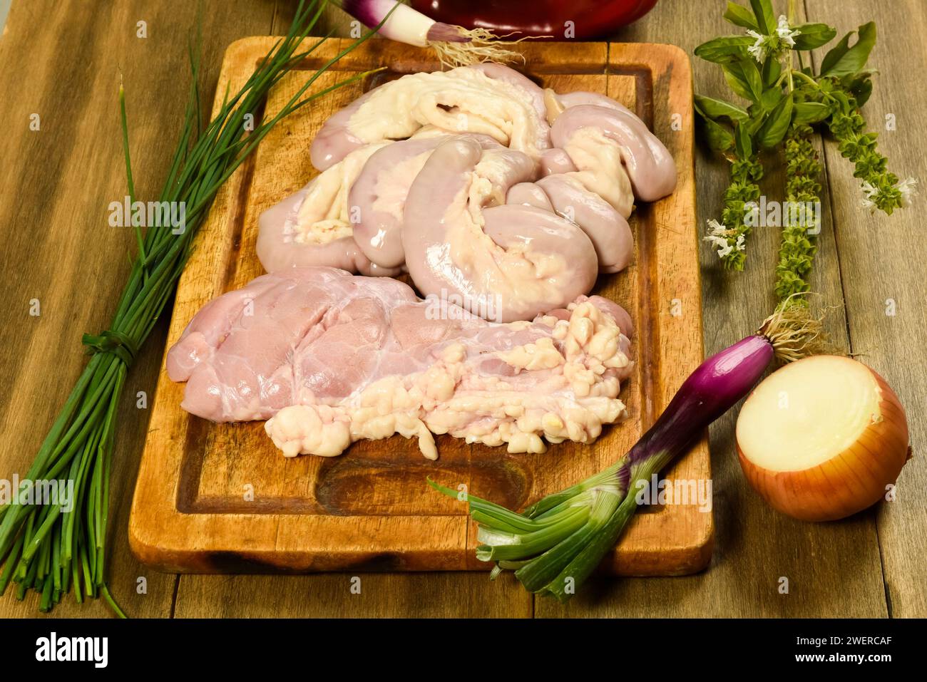 Cow bowels presented on a wooden board with ingredients, ready to grill ...