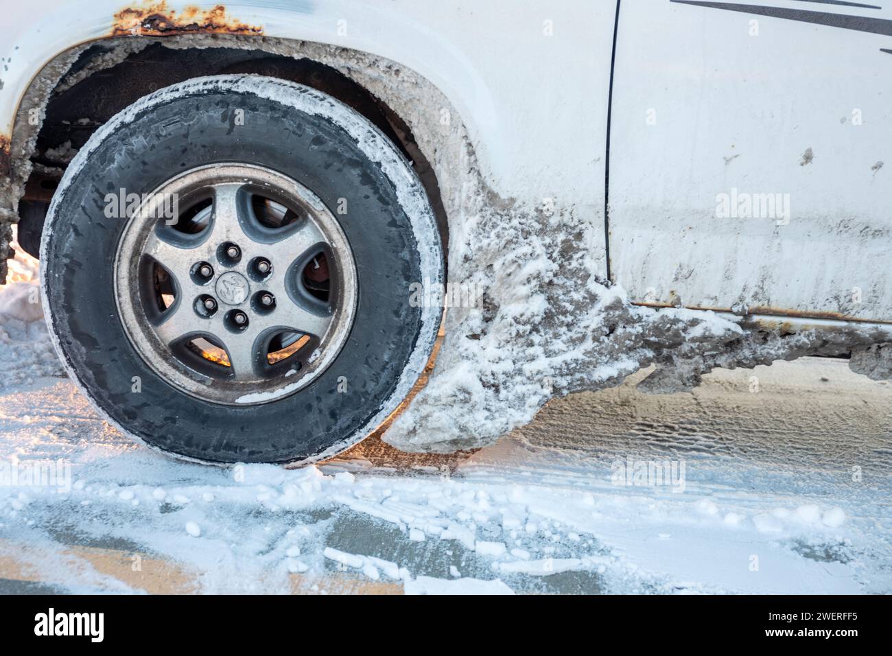 Front wheel of light truck showing snow and ice accumulated behind ...