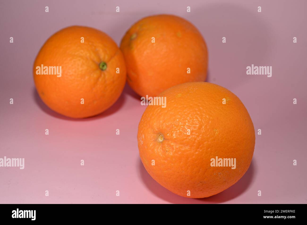 three juicy oranges on a pink background studio shooting 1 Stock Photo ...
