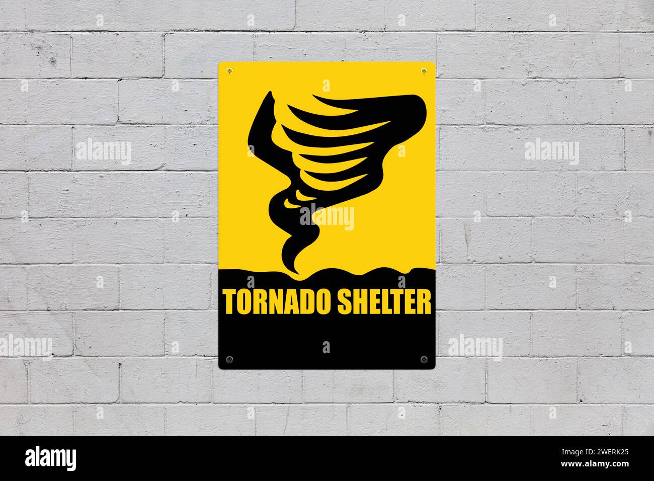 Yellow warning sign screwed to a brick wall to warn about a threat. In ...