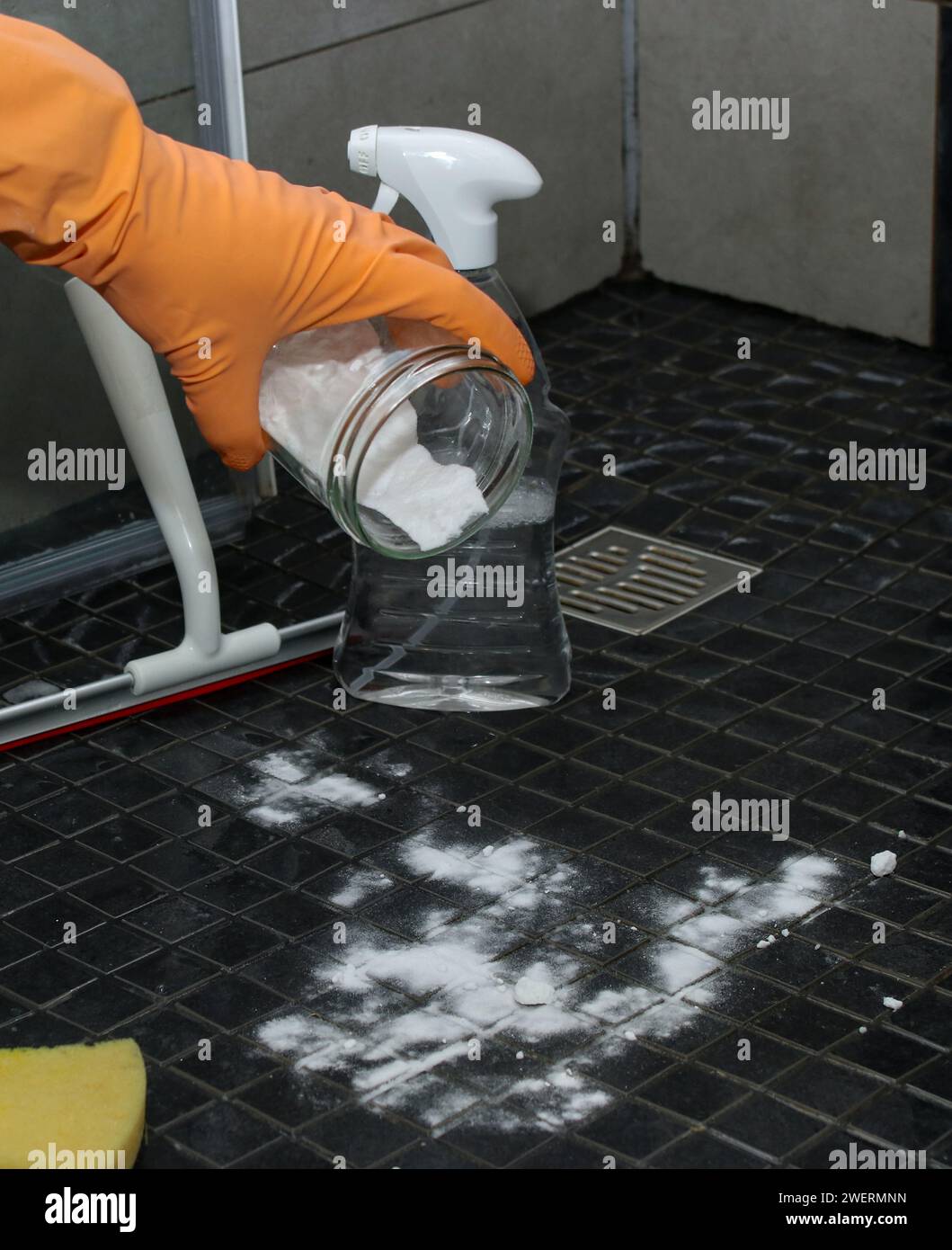 Close up of woman's hands pouring baking soda on shower floor to clean ...