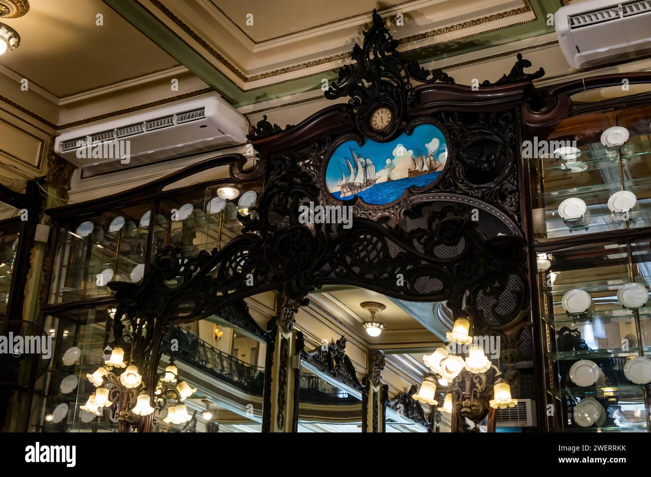 A big china cabinet with crystal mirrors displaying lots of porcelain ...