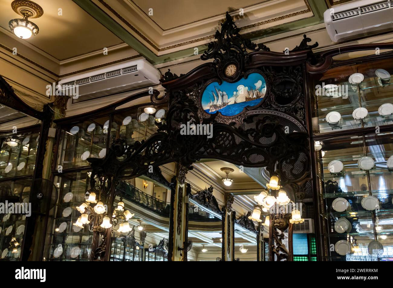 A big china cabinet with crystal mirrors displaying lots of porcelain ...