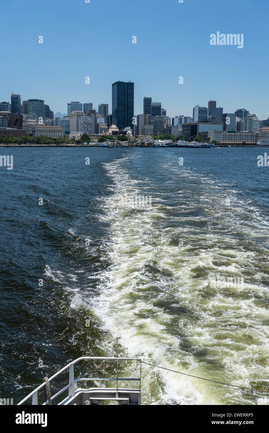 A big boat wake made by a ferry boat on Guanabara bay blue waters while ...