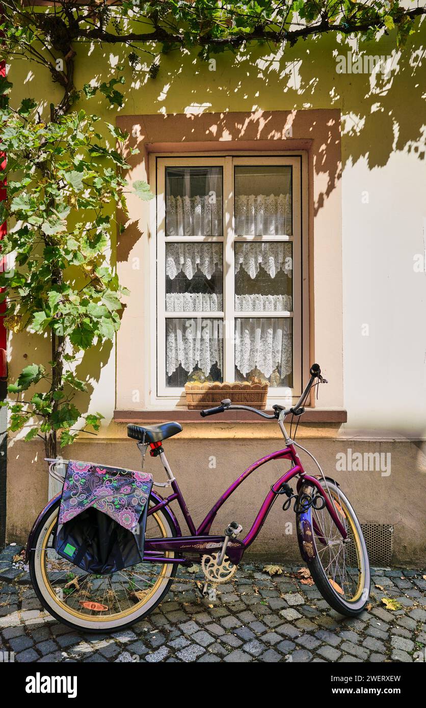 Classic European vignette of old purple bike parked in front of typical ...