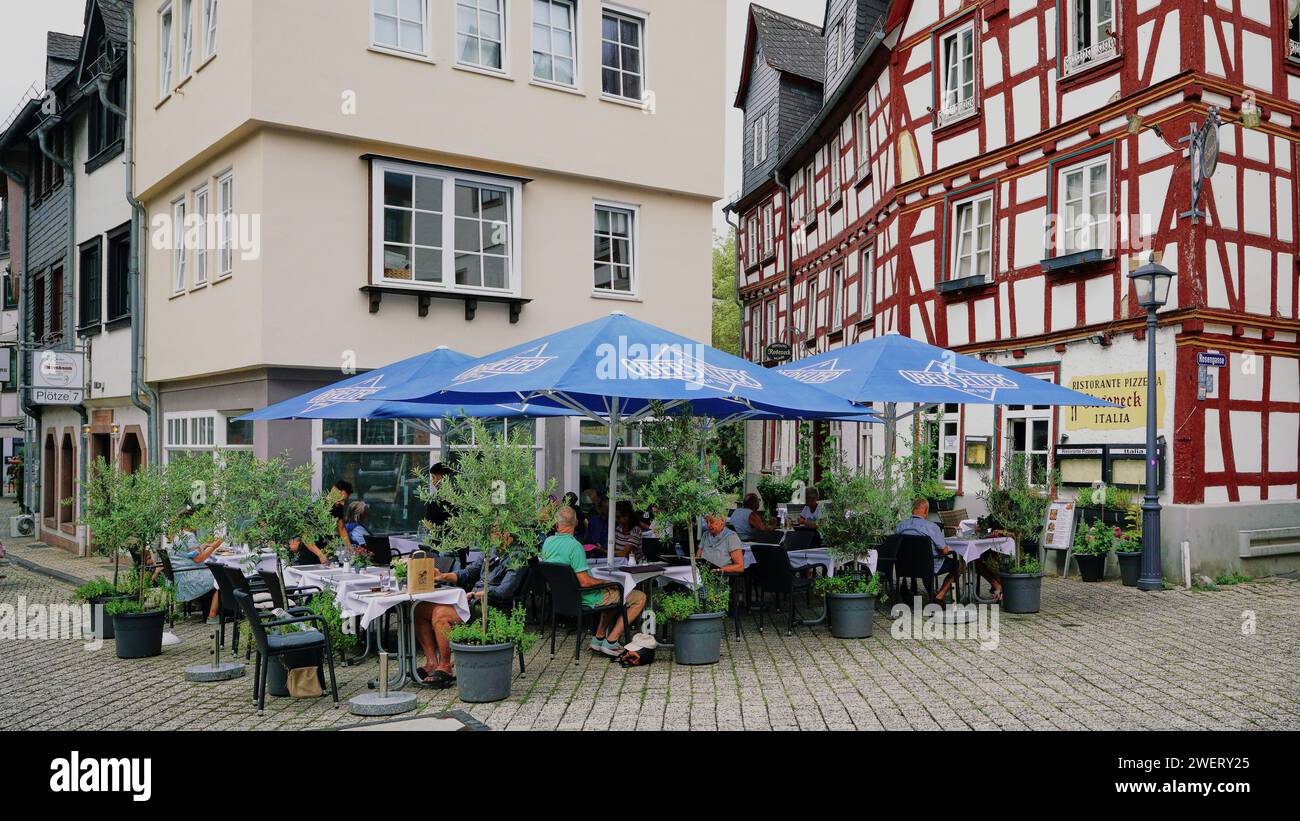 Crowded outdoor cafe in the medieval town square in the village of ...