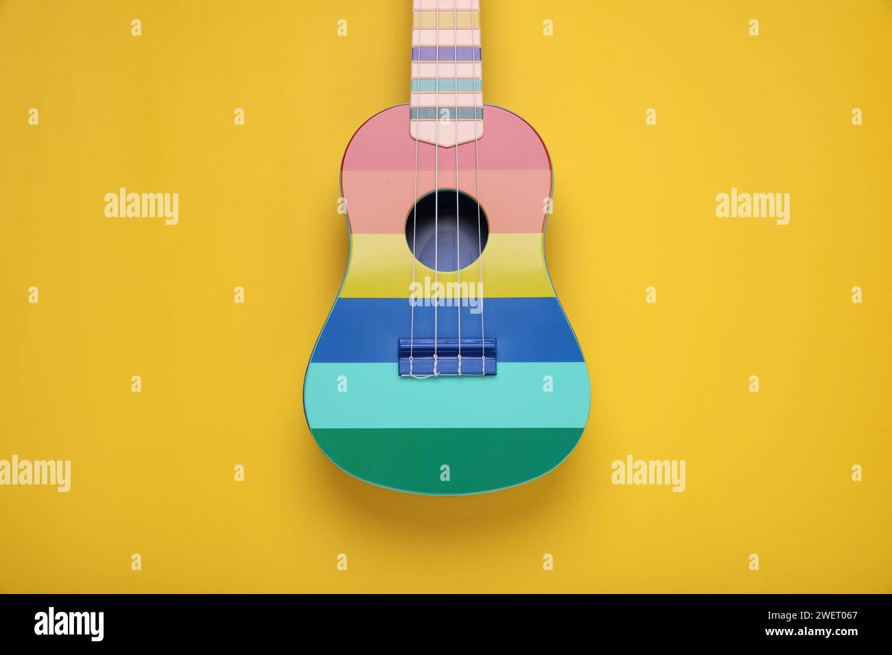 Colorful ukulele on yellow background, top view. String musical ...