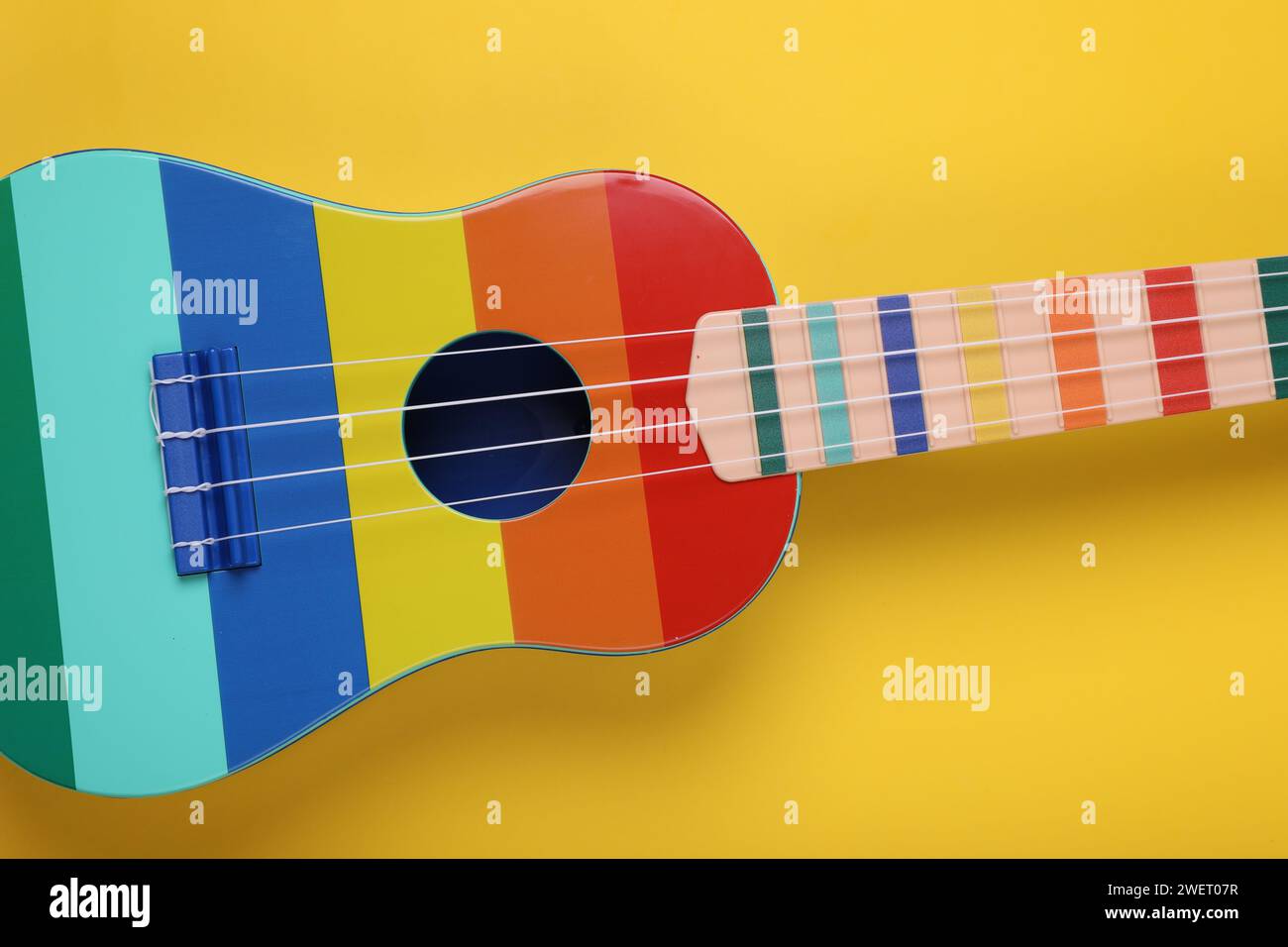 Colorful ukulele on yellow background, top view. String musical ...