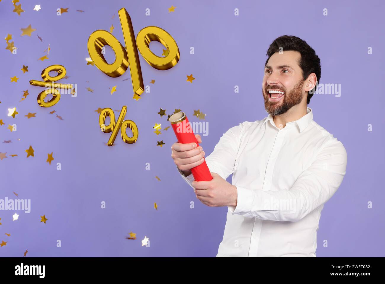 Discount offer. Happy man blowing up party popper on violet background ...