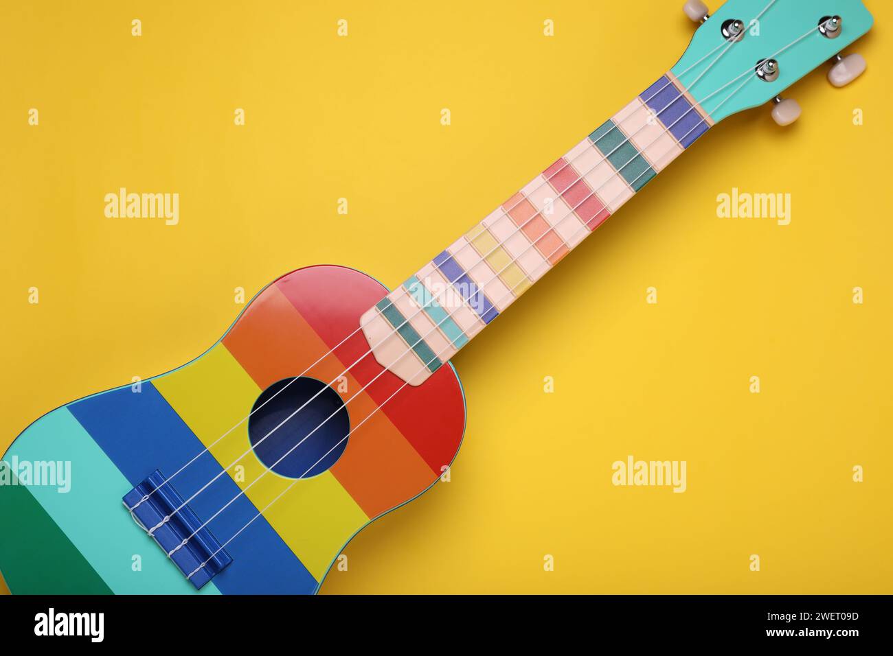 Colorful ukulele on yellow background, top view. String musical ...