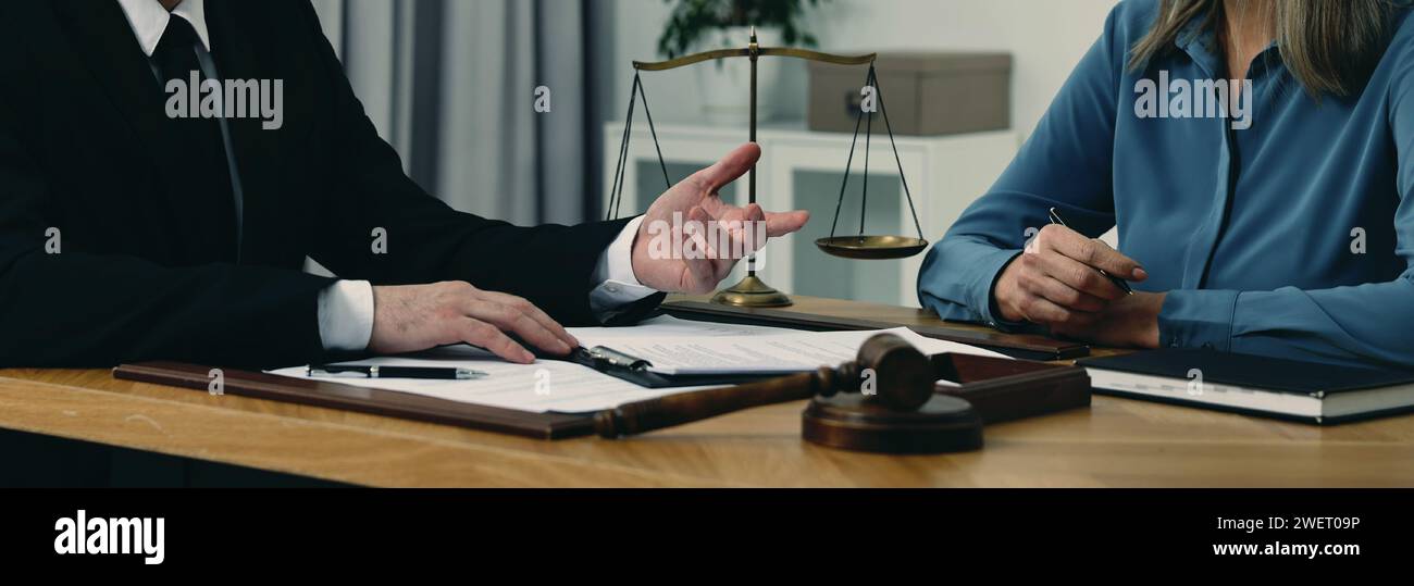 Lawyer working with client at wooden table in office, closeup. Banner ...