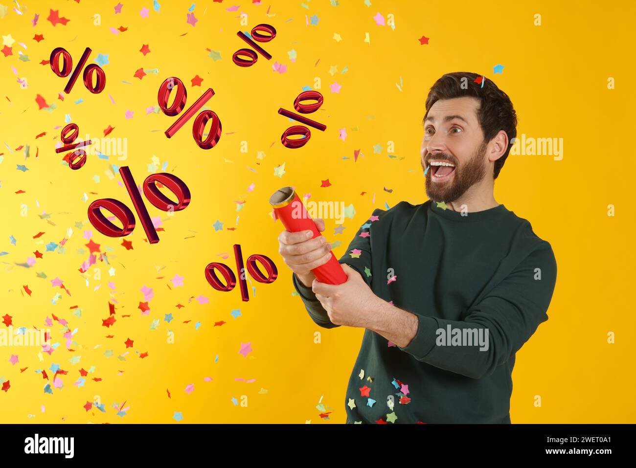 Discount offer. Happy man blowing up party popper on golden background ...