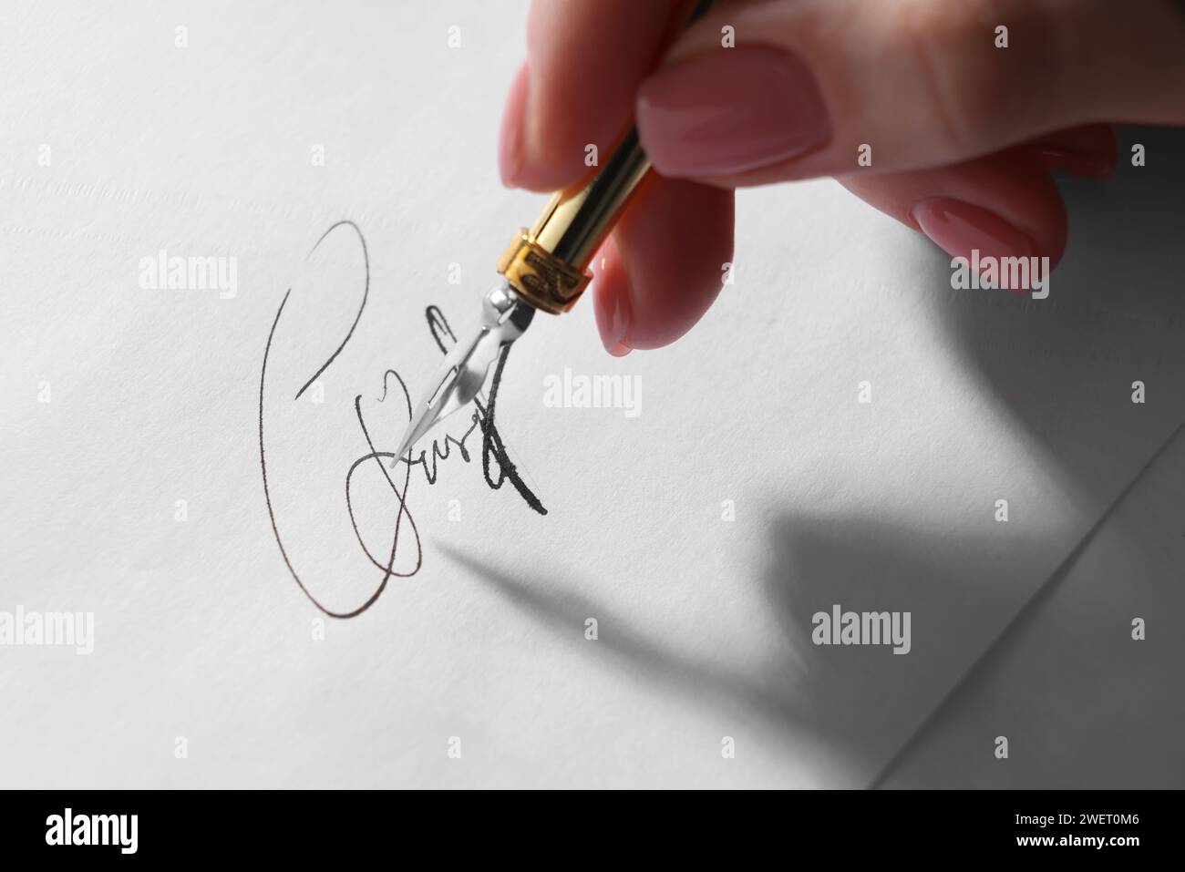 Woman signing on sheet of paper with fountain pen, closeup Stock Photo ...