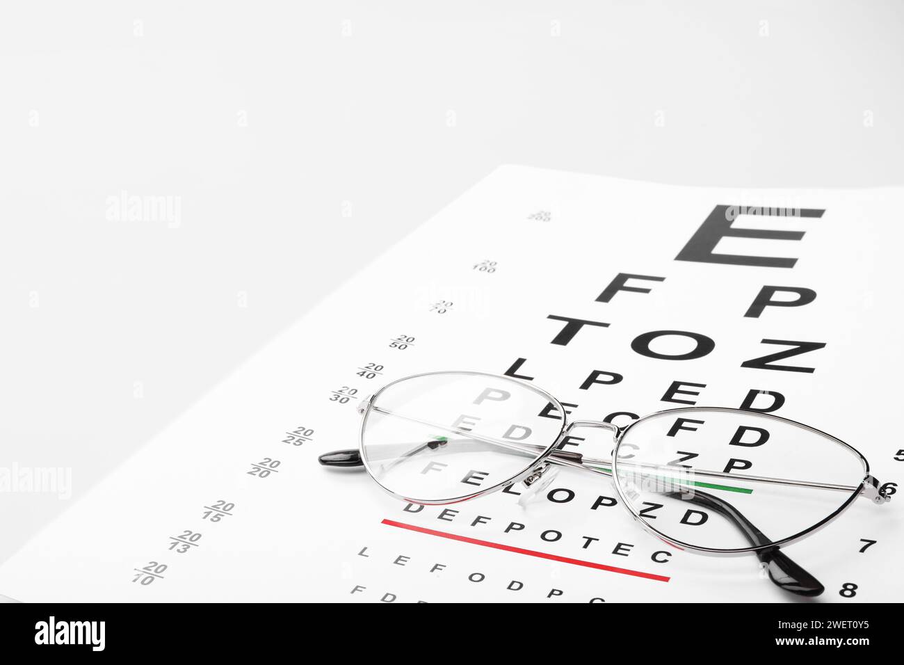 Glasses and vision test chart isolated on white Stock Photo - Alamy