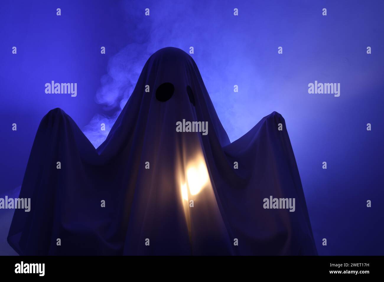 Creepy ghost. Woman covered with sheet in blue light Stock Photo - Alamy