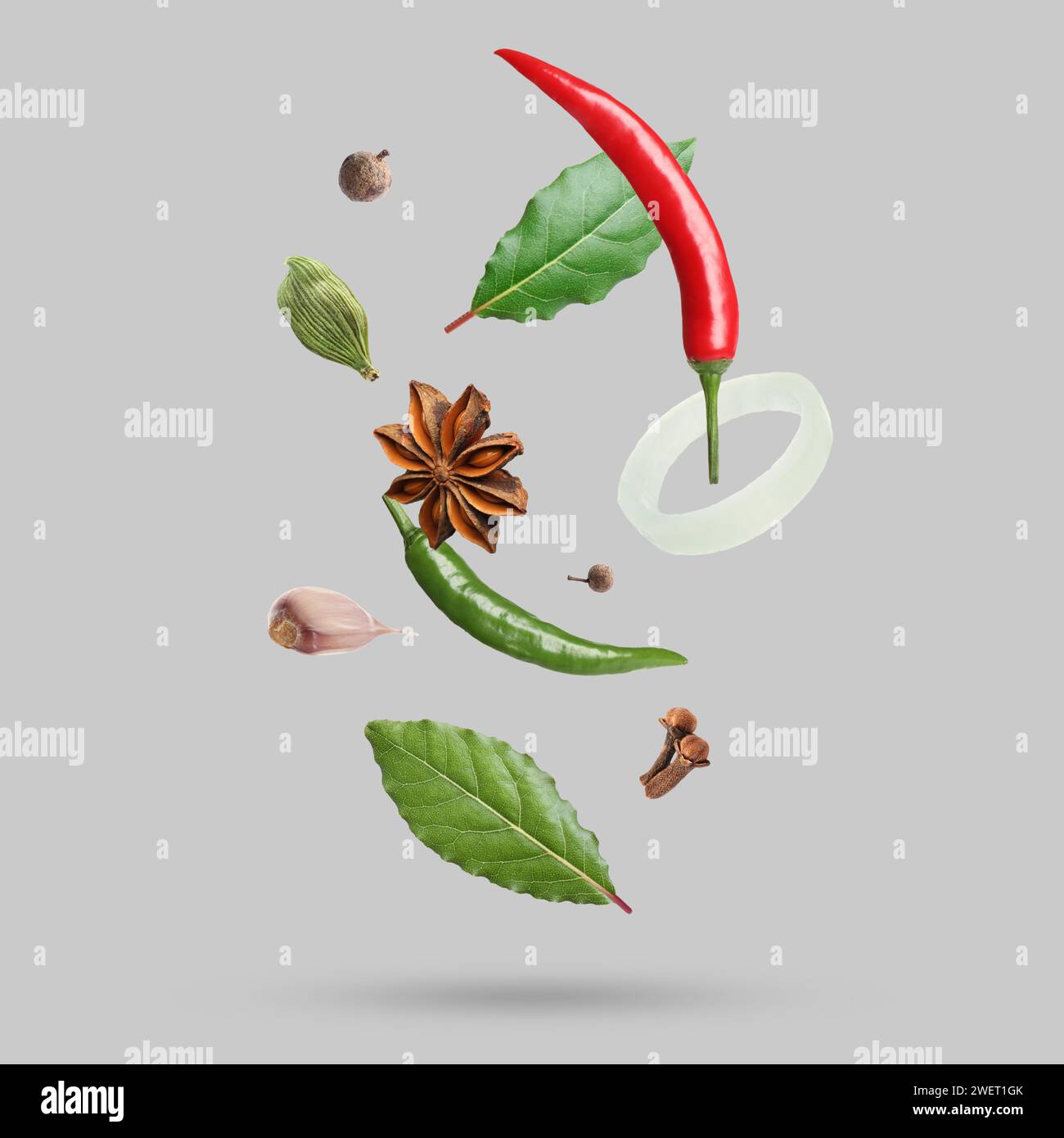 Different spices falling on light grey background Stock Photo - Alamy