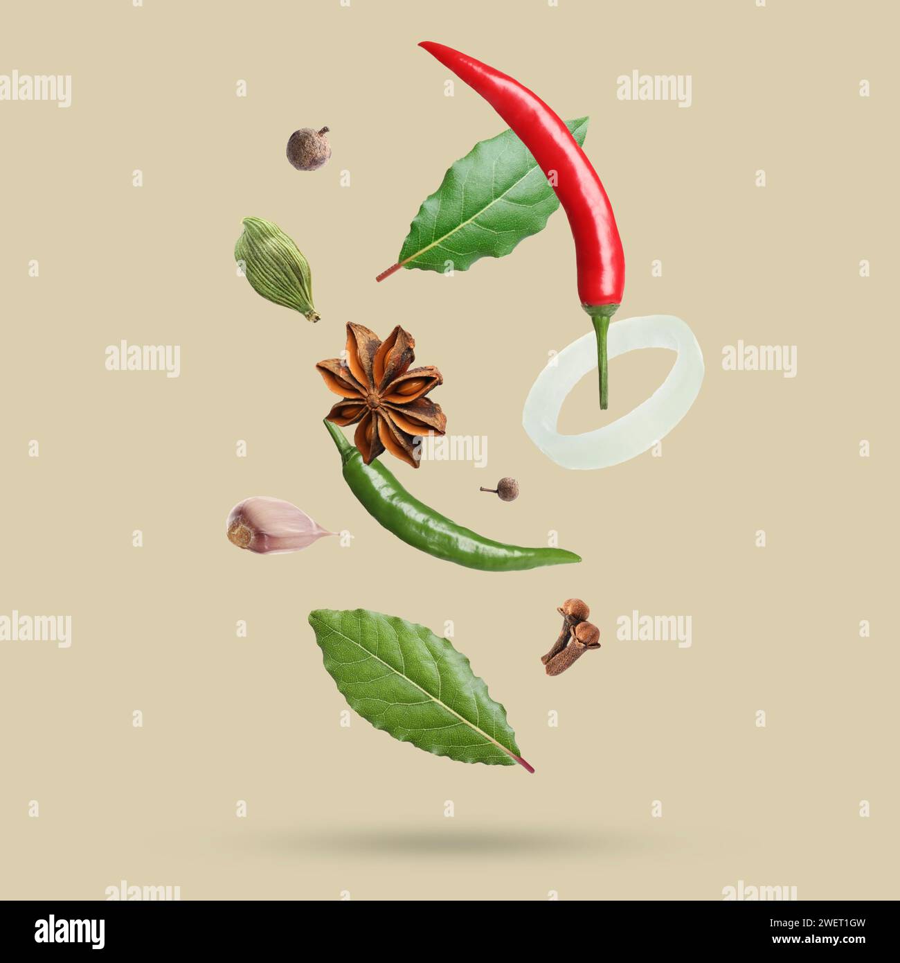 Different spices falling on dark beige background Stock Photo - Alamy