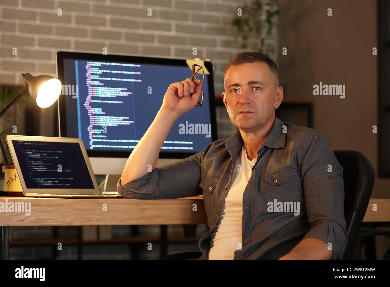 Mature male programmer working in office at night Stock Photo - Alamy