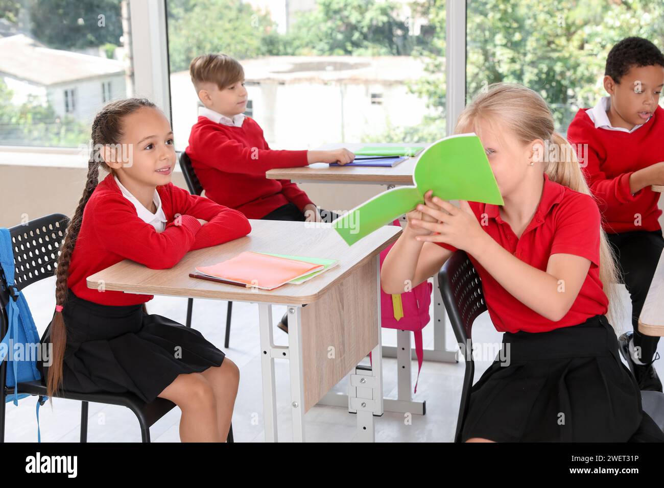 Little classmates sitting at desks during lesson in classroom Stock ...