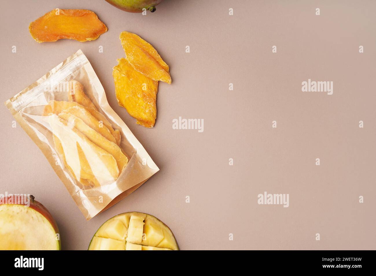Package with slices of dried mango on beige background Stock Photo - Alamy