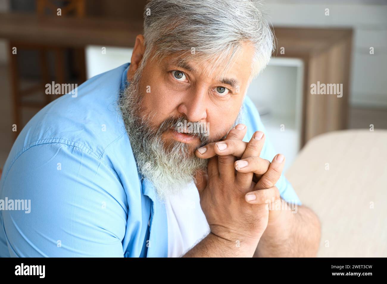 Afraid mature man at table in kitchen Stock Photo - Alamy