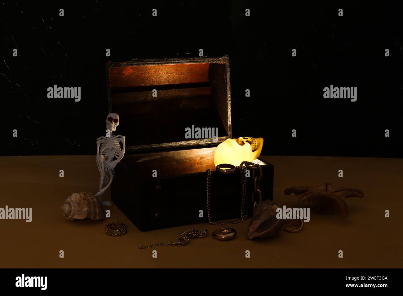 Old chest with treasures, seashells and skeleton on dark background ...