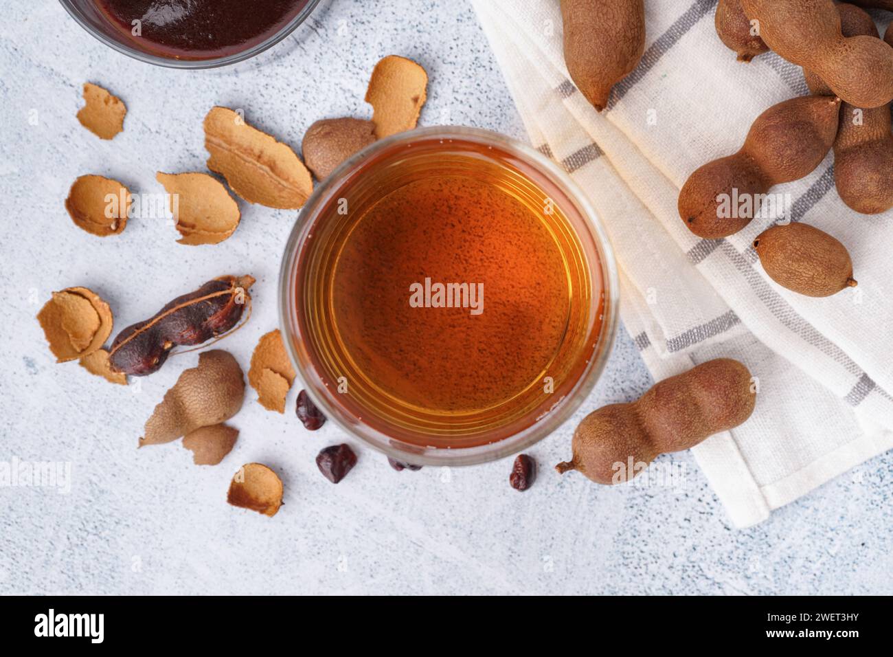 Glass of tasty tamarind drink and fruits on white background Stock ...