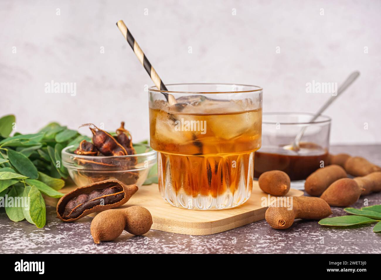 Glass of tasty tamarind drink and fruits on table Stock Photo - Alamy