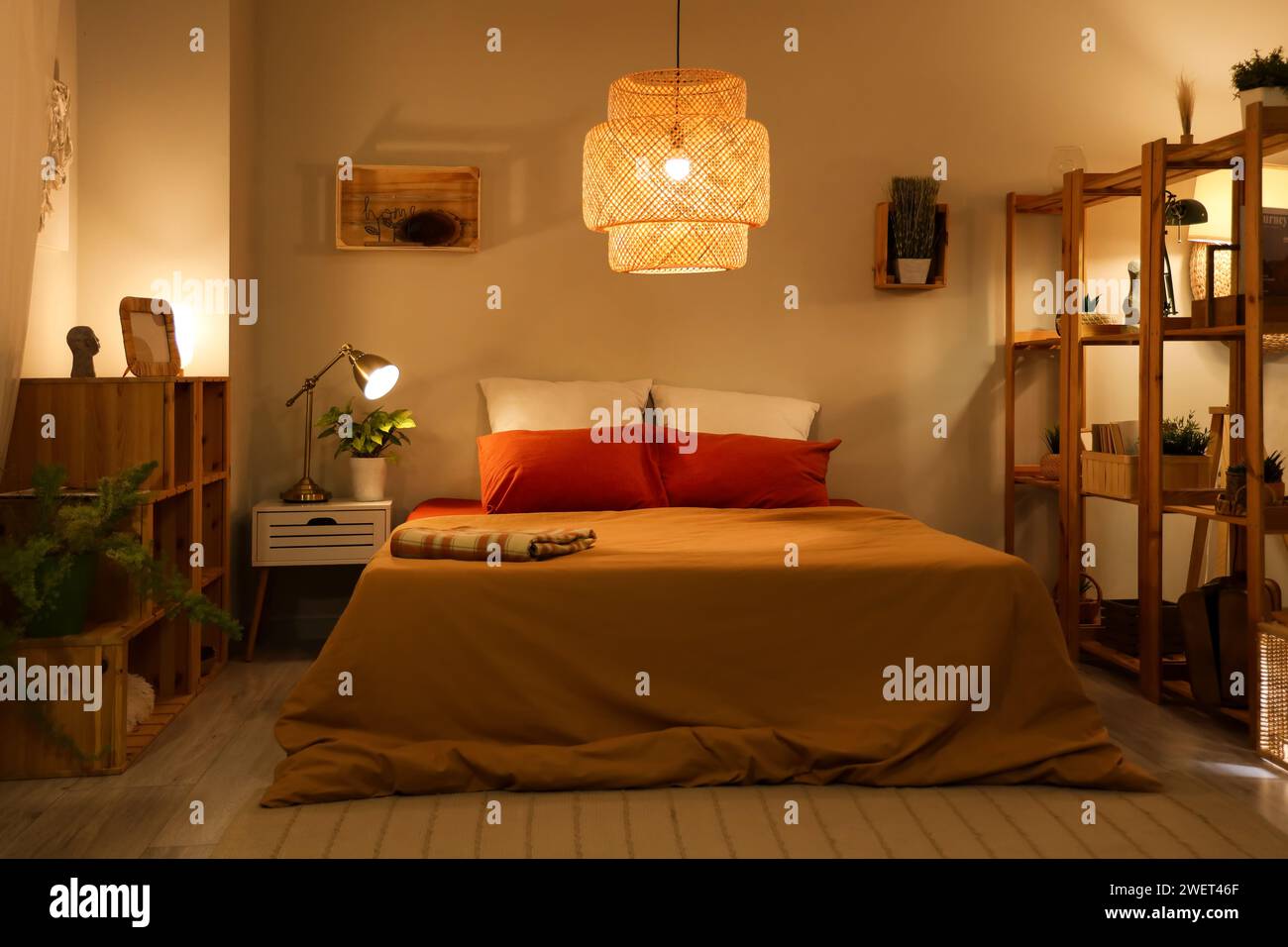 Interior of cozy bedroom with shelf units and glowing lamps at night ...