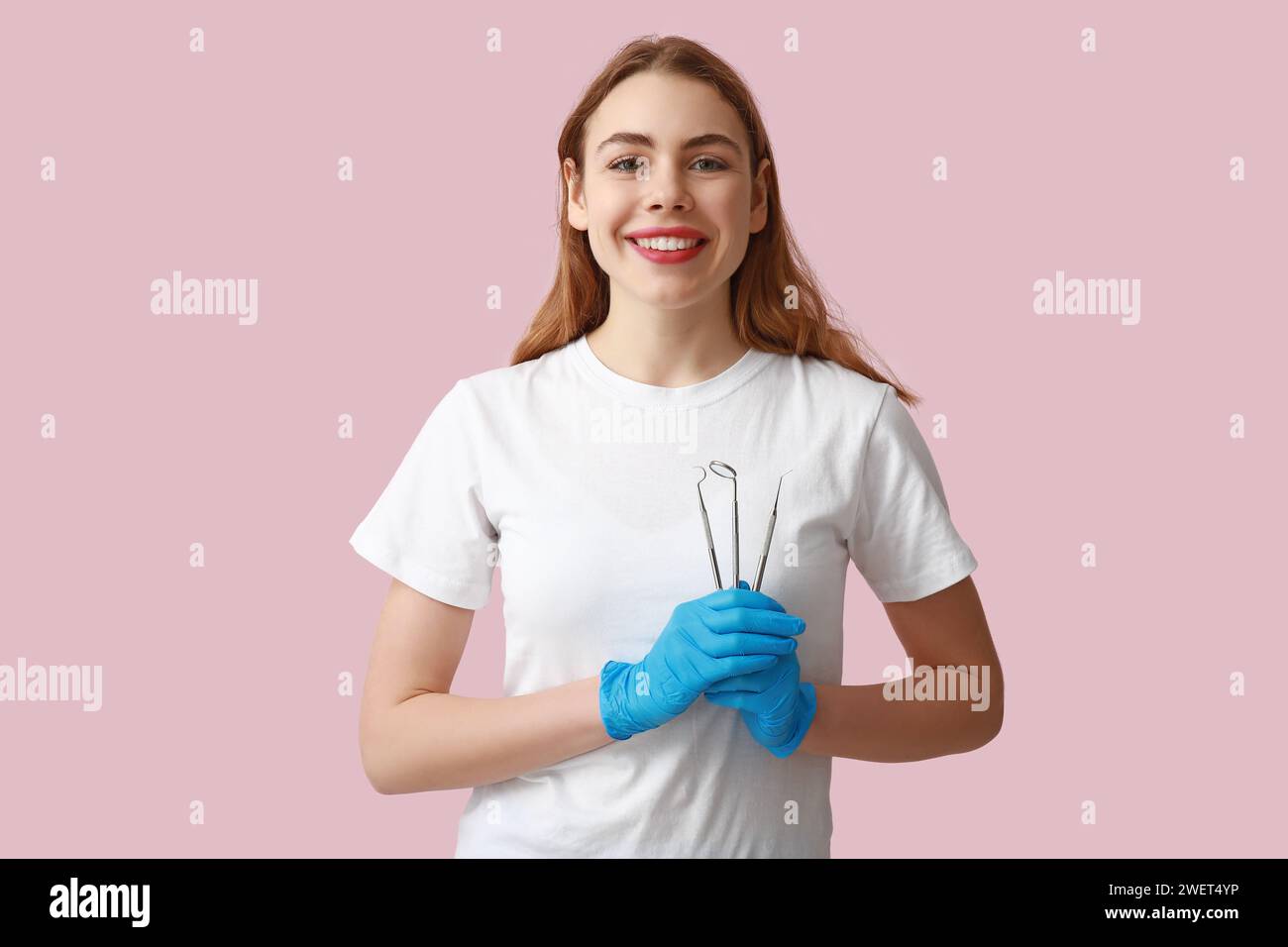 Female dentist with dental tools on pink background. World Dentist Day ...