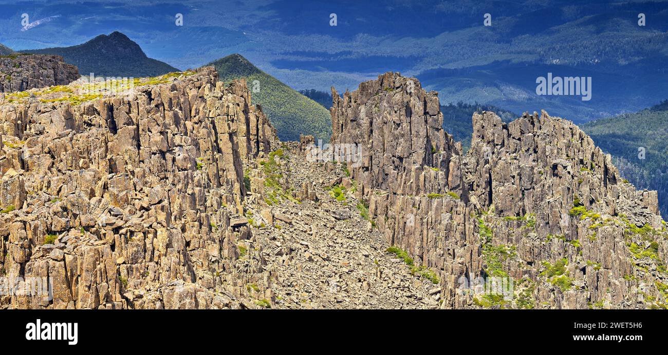 Craggy dolerite cliffs and columns in sun and shadow with view to ...