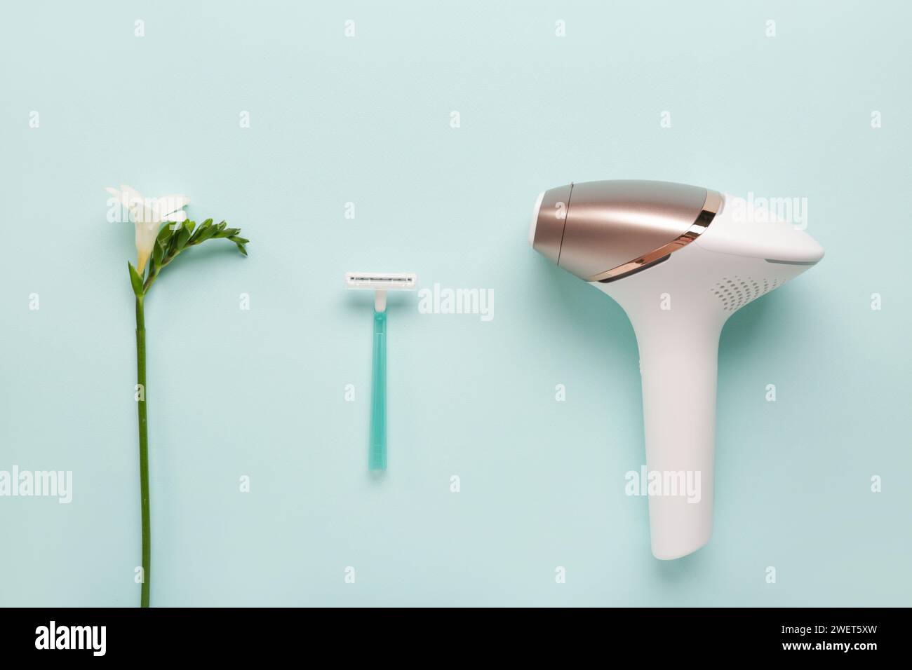 Modern photoepilator with razor and flower on blue background Stock ...