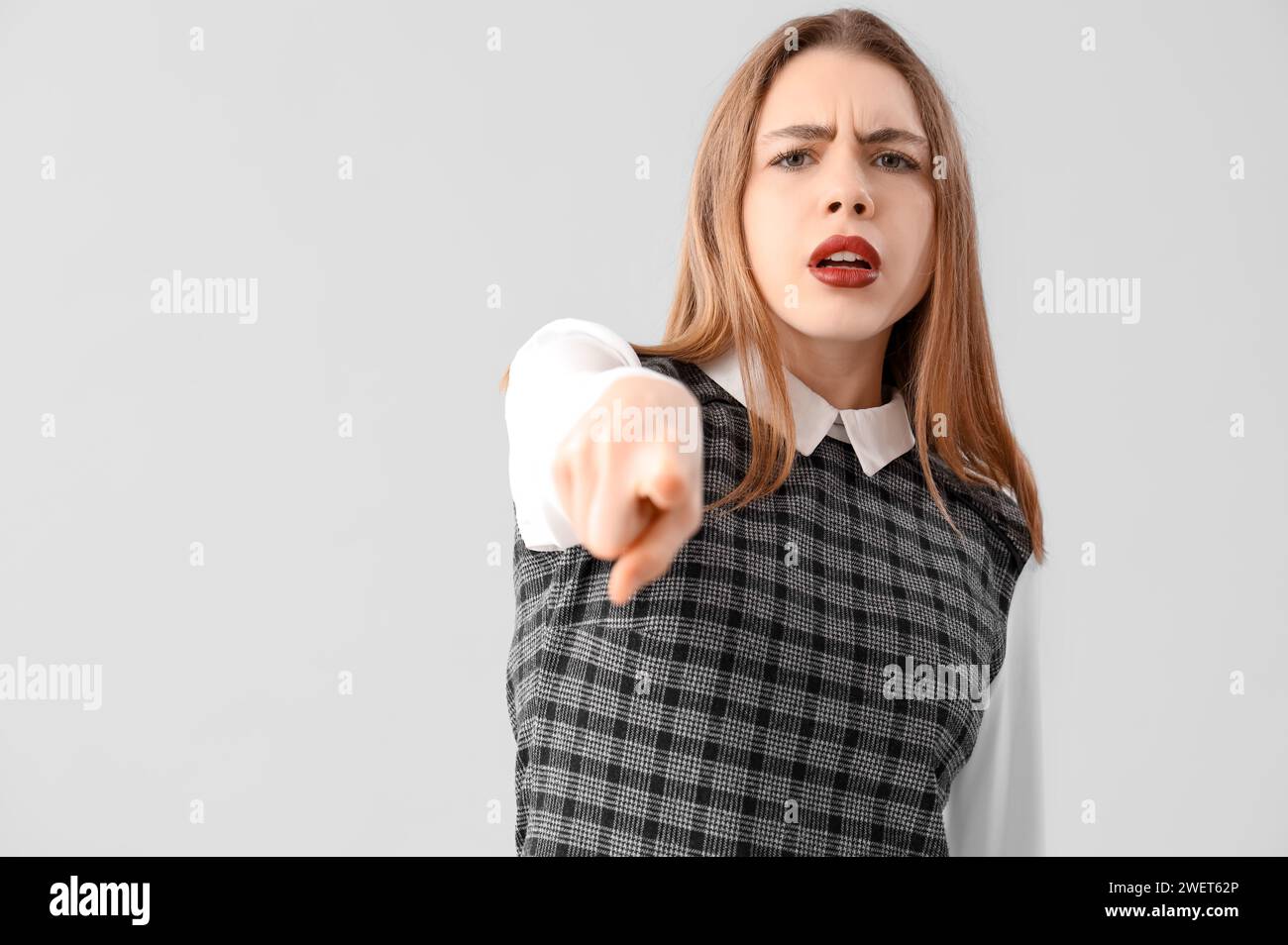 Young businesswoman pointing at viewer on light background. Accusation ...