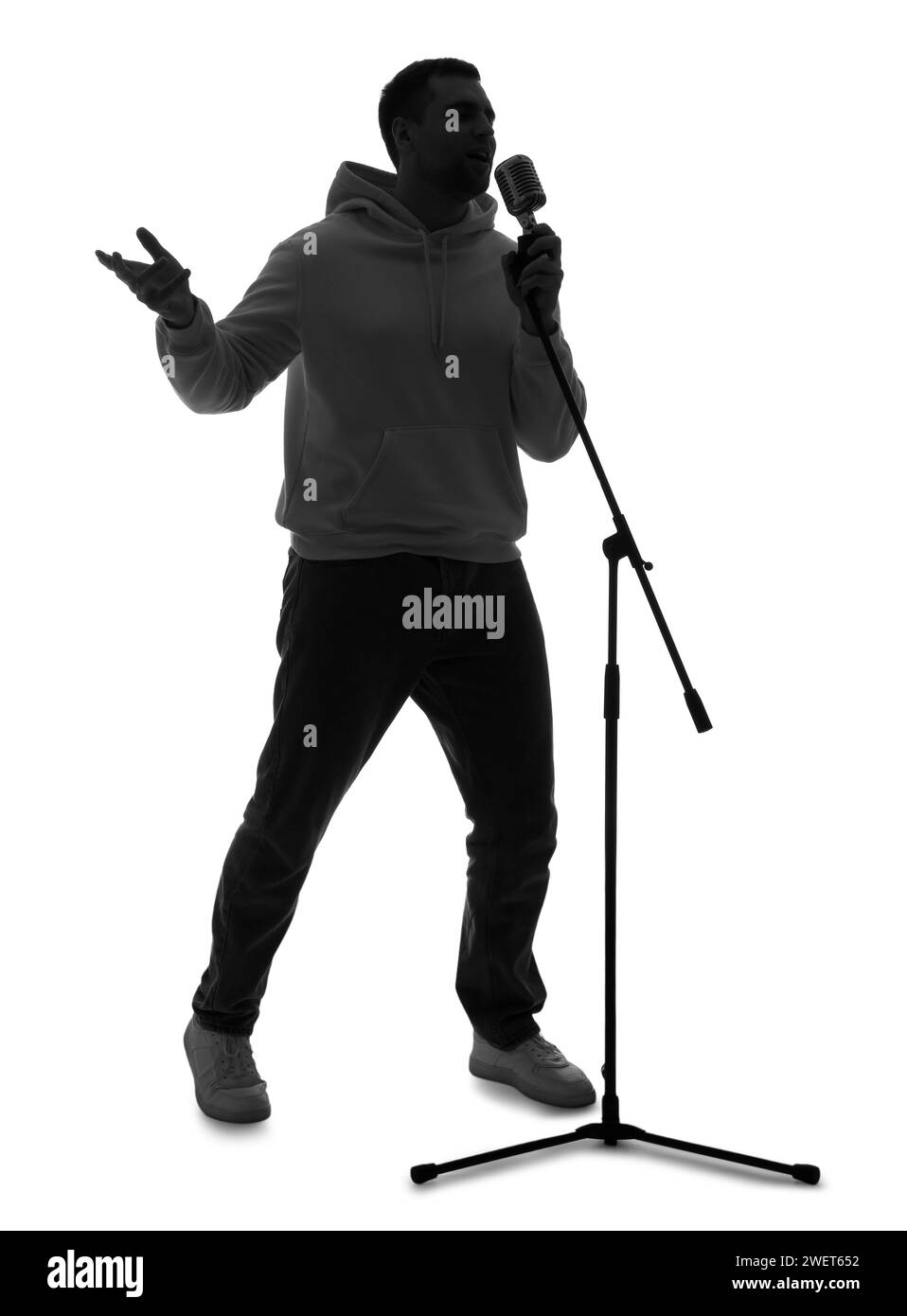 Silhouette of singing young man with microphone on white background ...