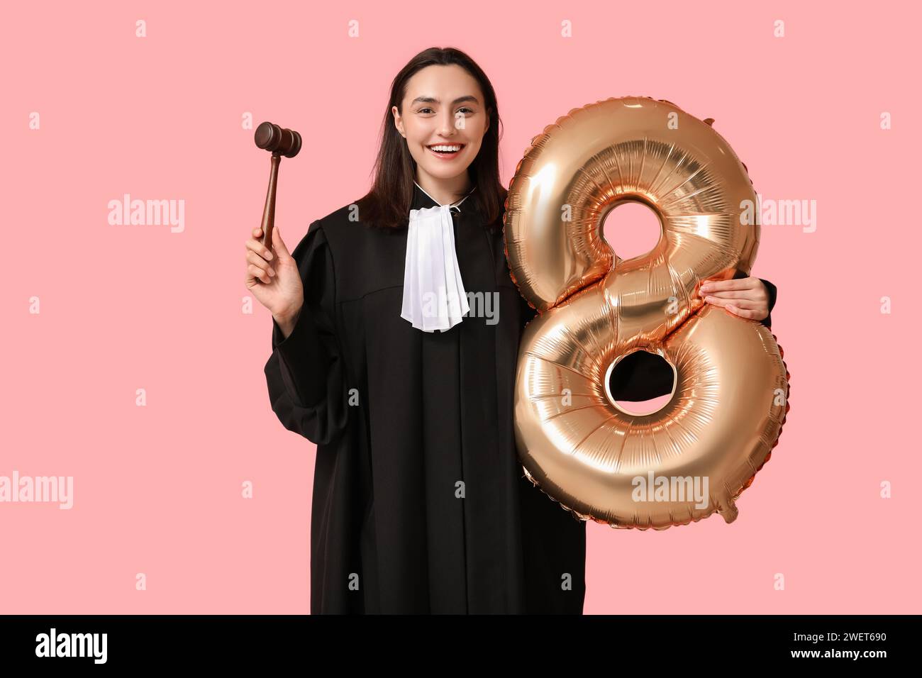 Portrait of young female judge with balloon in shape of figure 8 on ...