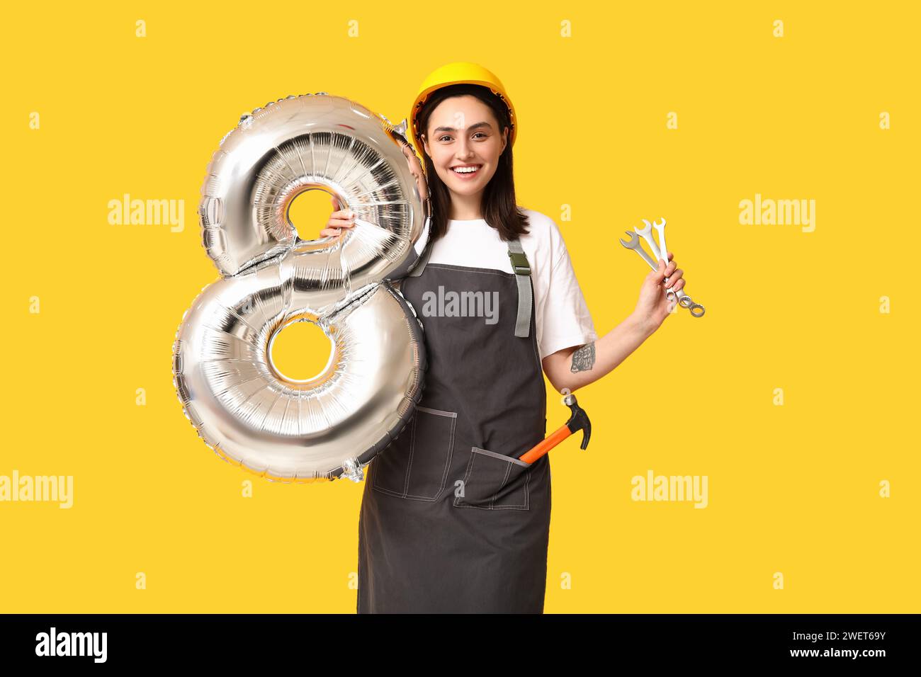 Portrait of young female construction worker with balloon in shape of ...