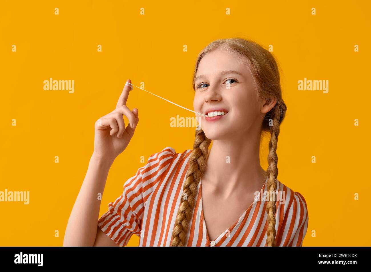 Teenage girl chewing gum on yellow background Stock Photo - Alamy